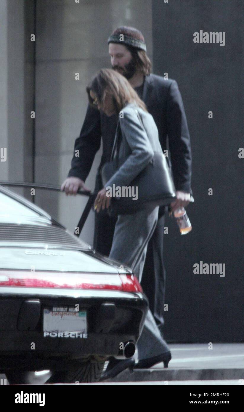 Exclusive!! A sad looking Keanu Reeves tenderly opens the car door for ...