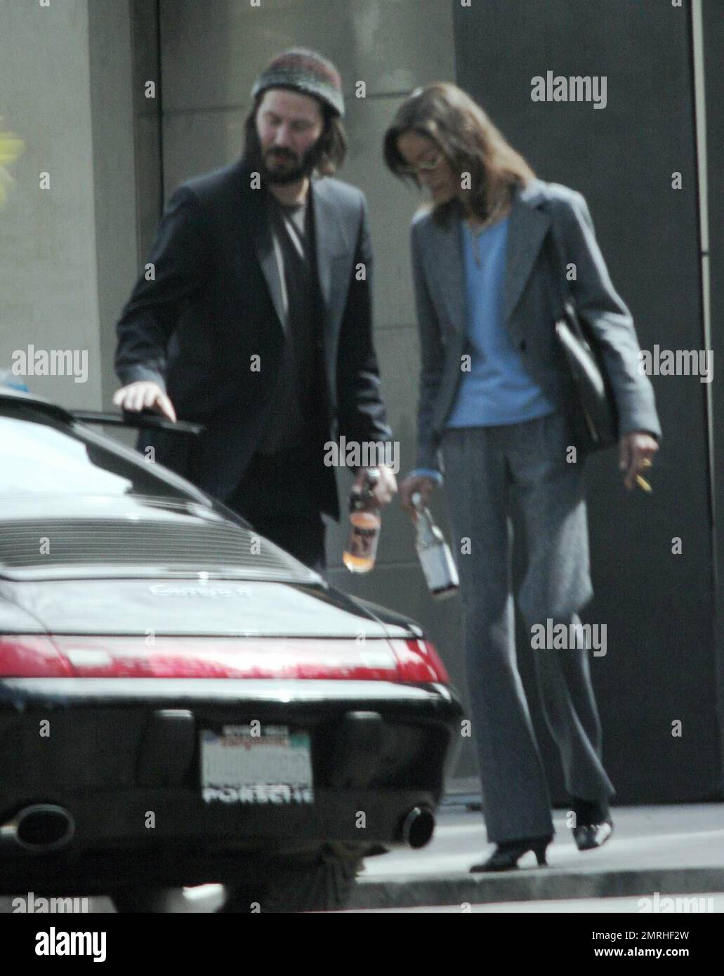 Exclusive!! A sad looking Keanu Reeves tenderly opens the car door for ...