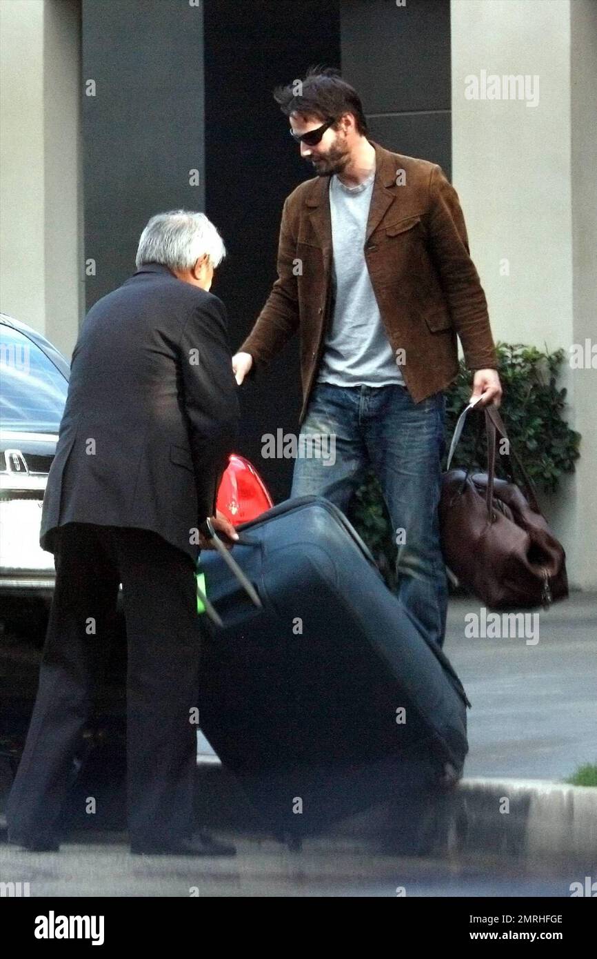 EXCLUSIVE!! Keanu Reeves is met by a driver as he leaves on a trip. The ...