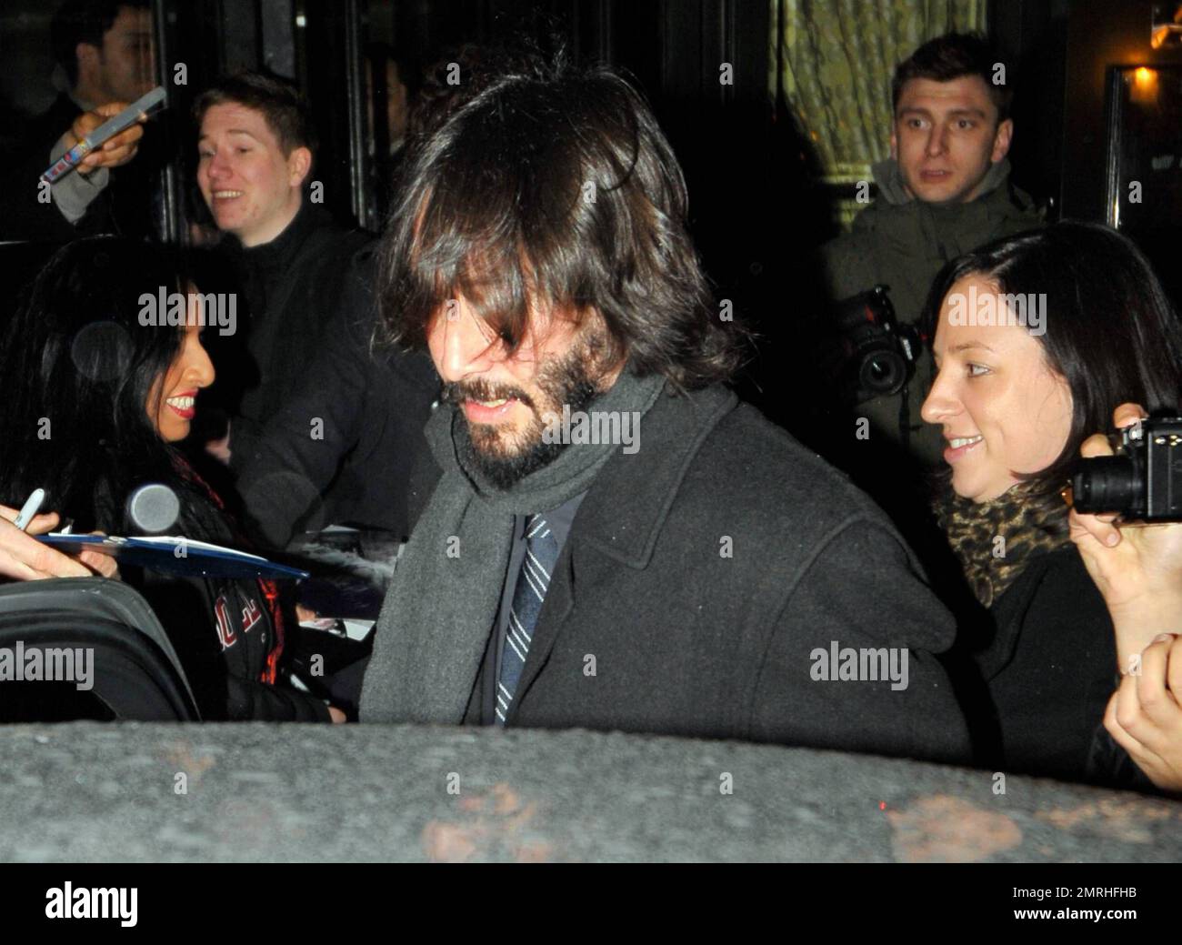 Actor Keanu Reeves leaves his hotel, making his way through a huge ...
