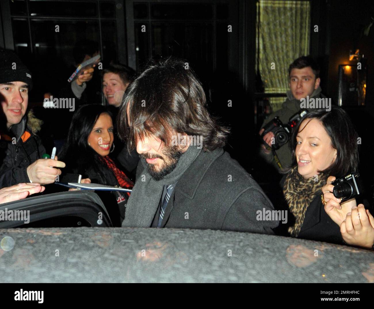 Actor Keanu Reeves leaves his hotel, making his way through a huge ...