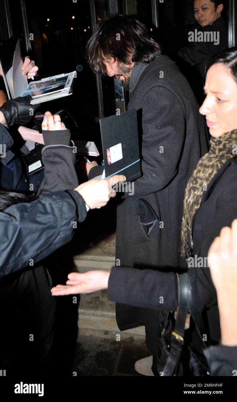 Actor Keanu Reeves leaves his hotel, making his way through a huge ...