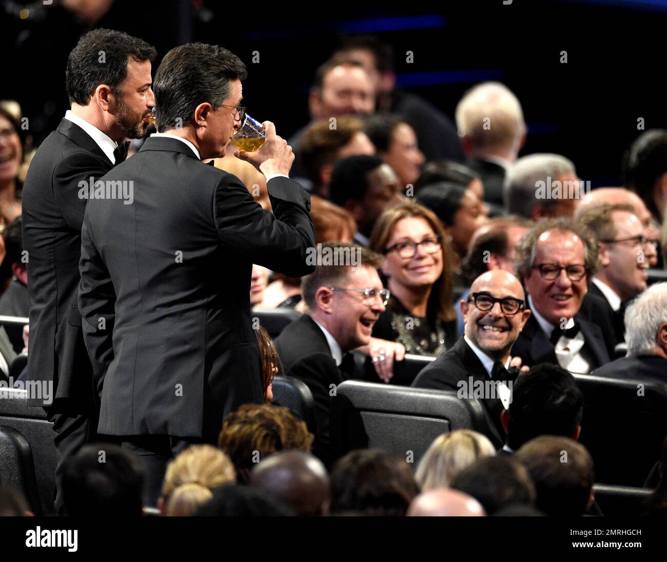 Jimmy Kimmel, left, and host Stephen Colbert drink in the audience at ...
