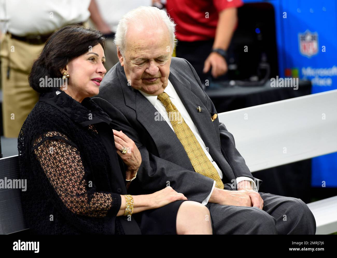 New Orleans Saints owner Tom Benson sits on the sideline with his wife ...