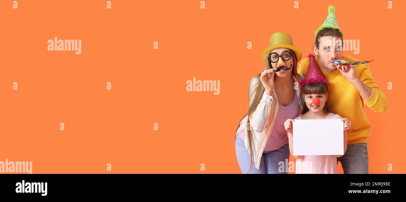 Happy family in funny disguise and with blank paper sheet on orange ...