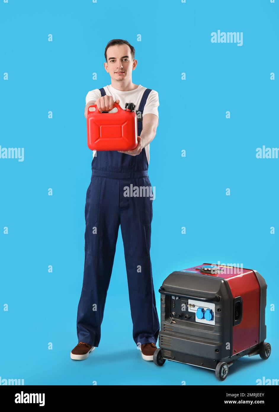 Male worker with canister and portable gasoline generator on blue ...