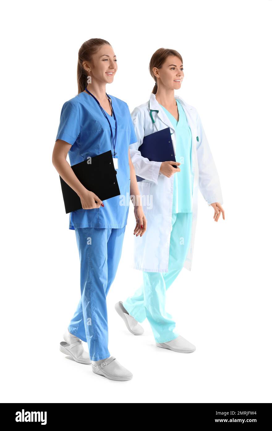 Female doctor and intern with clipboards on white background Stock ...