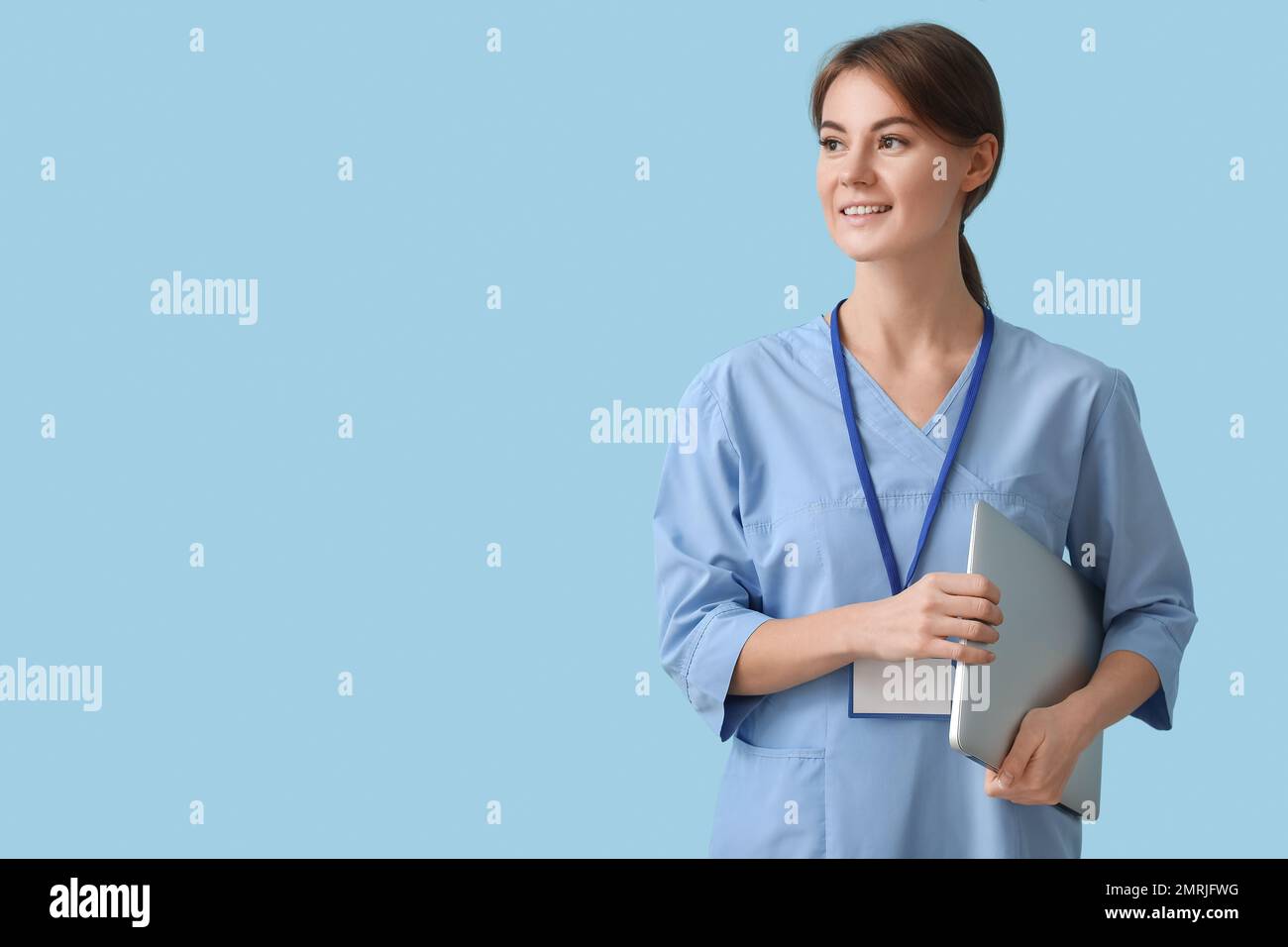 Female medical intern with laptop on blue background Stock Photo - Alamy