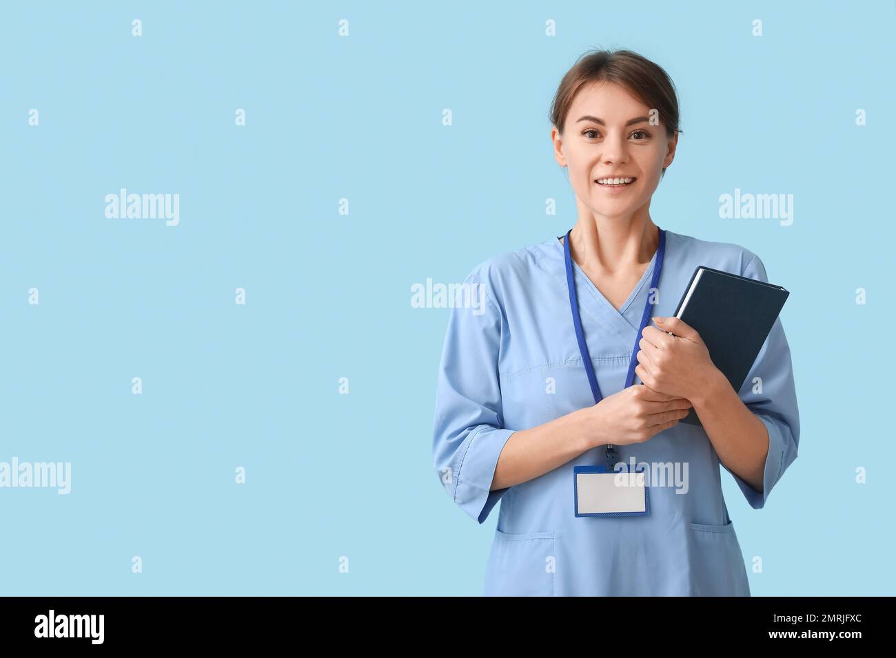 Female medical intern with book on blue background Stock Photo - Alamy