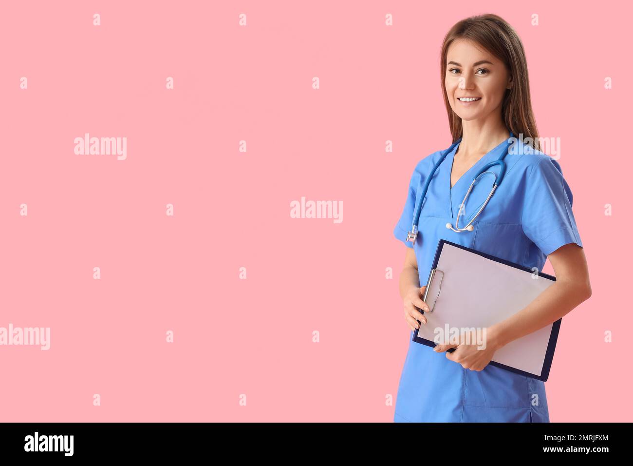 Female medical intern with clipboard on pink background Stock Photo - Alamy