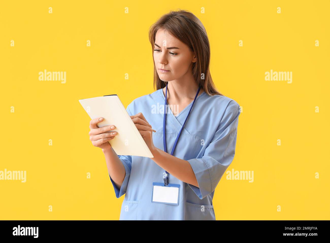 Female medical intern with folder on yellow background Stock Photo - Alamy