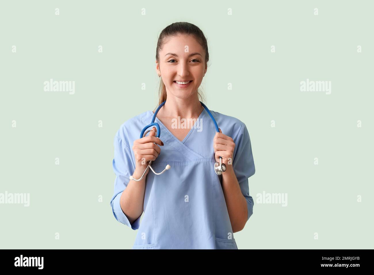 Female medical intern with stethoscope on green background Stock Photo ...