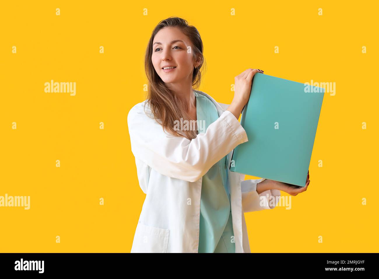 Female doctor with folder on yellow background Stock Photo - Alamy