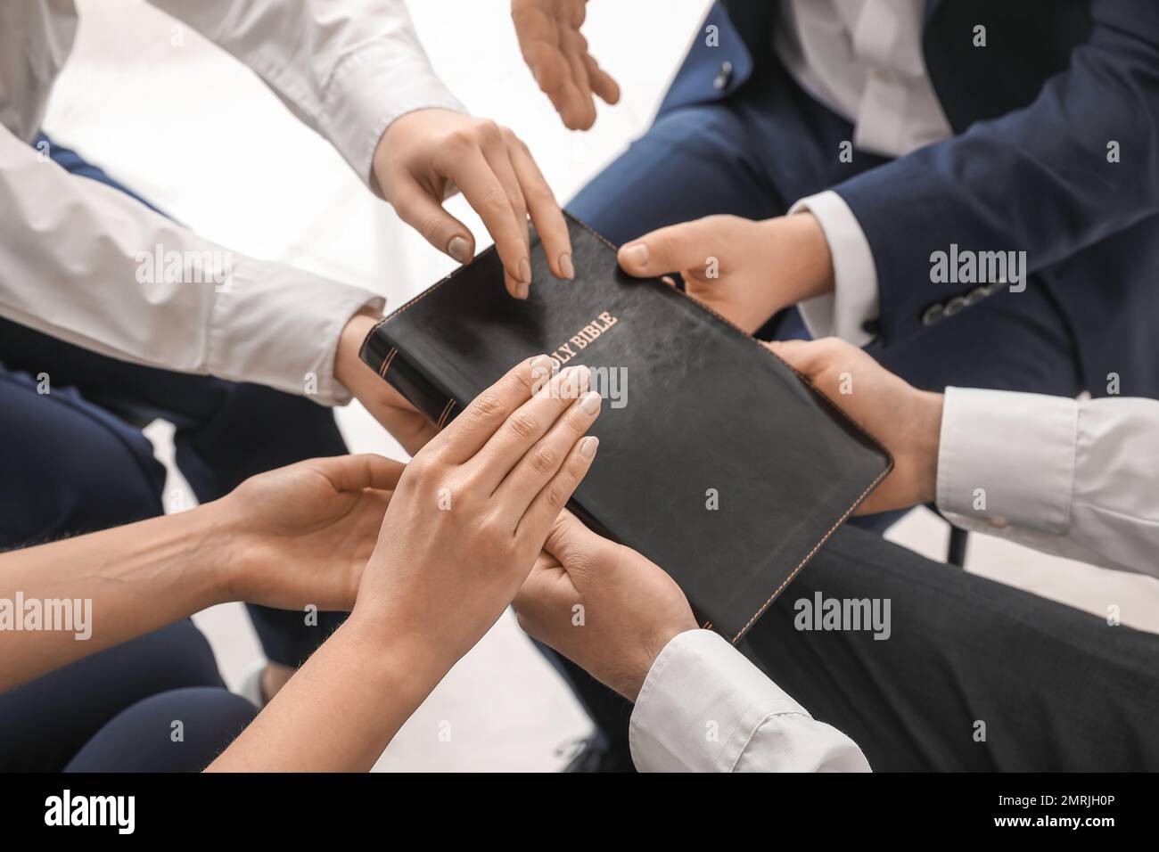 Group of people praying with Holy Bible in office, closeup Stock Photo ...
