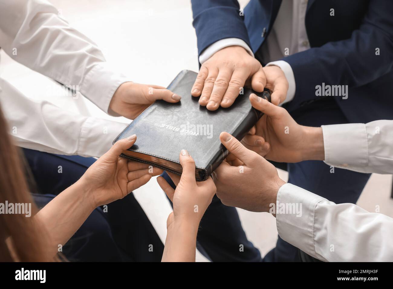 Group of people praying with Holy Bible in office, closeup Stock Photo ...