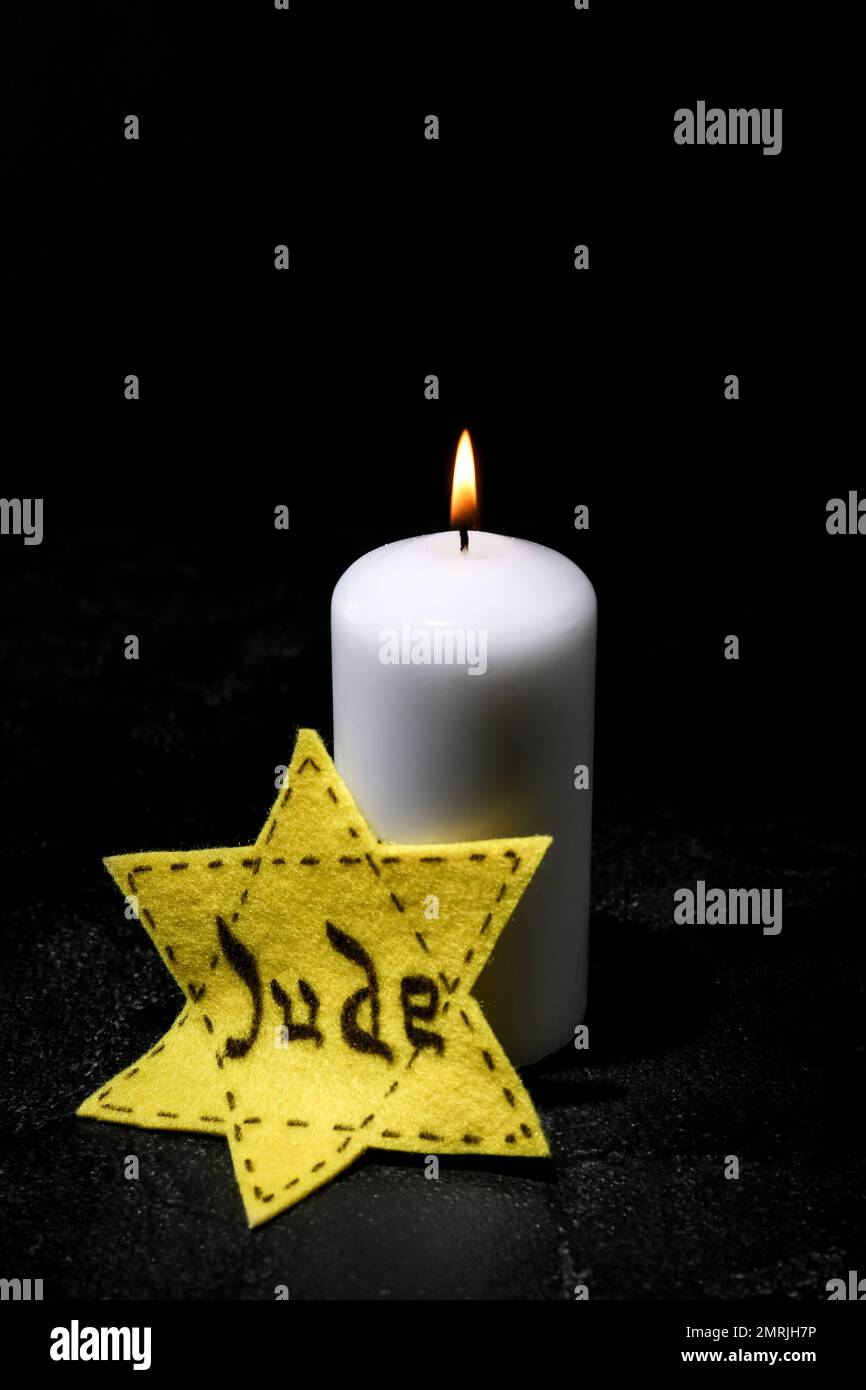 Burning candle and Jewish badge on dark background. International ...