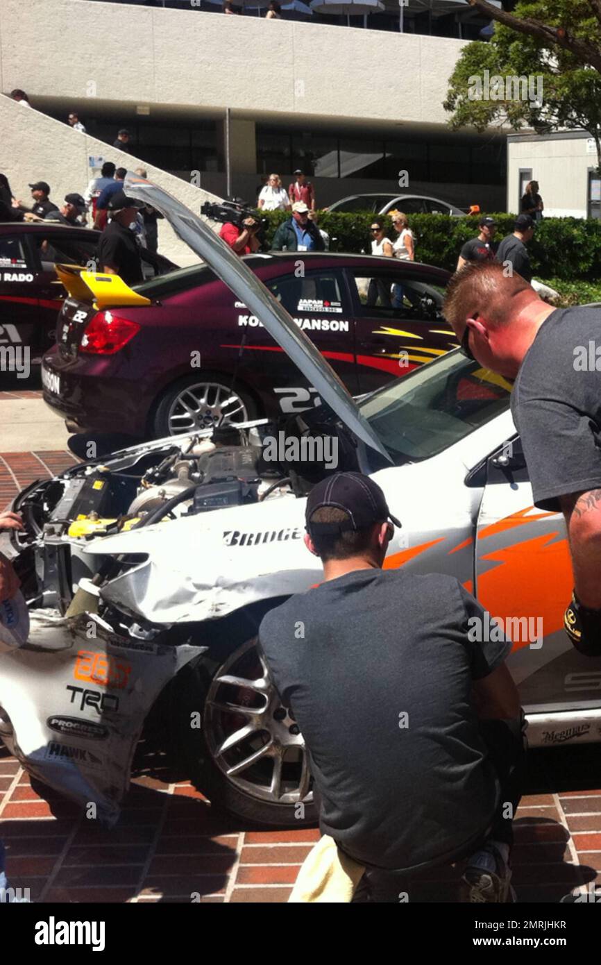 Workers attend to the banged up car of singer Kevin Jonas during the ...