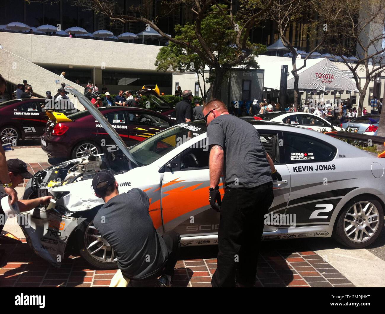 Workers attend to the banged up car of singer Kevin Jonas during the ...