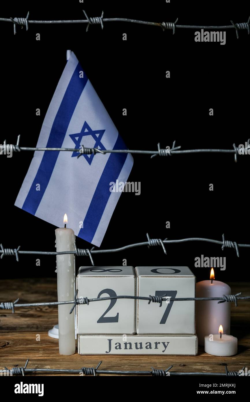 Calendar with date 27 JANUARY, burning candles, barbed wire and flag of ...