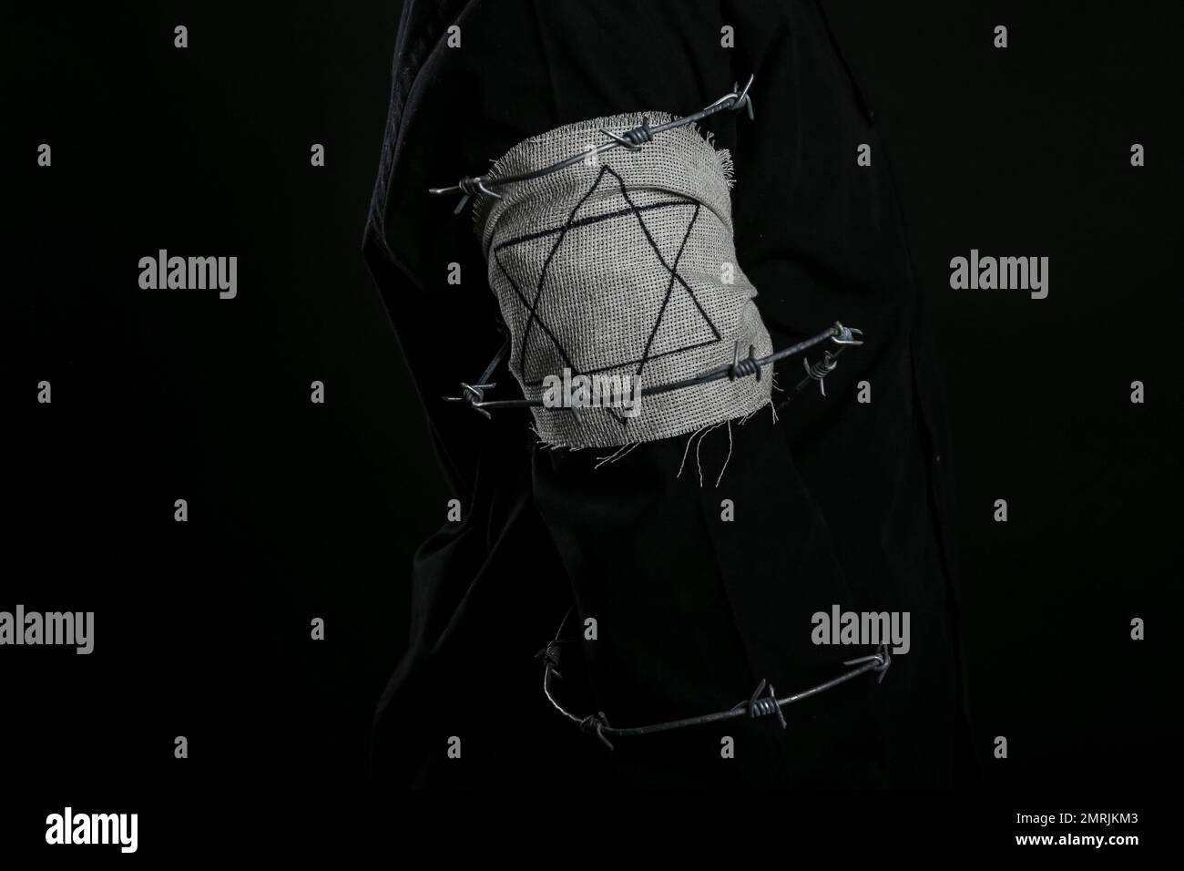 Jewish man with armband and barbed wire on black background ...