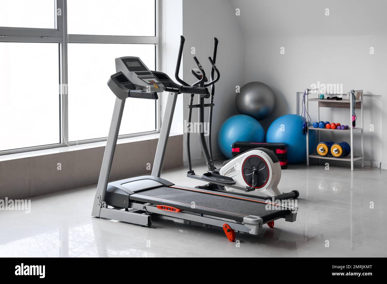 Interior of gym with modern treadmill, elliptical trainer and sport ...
