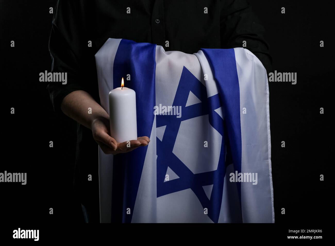 Jewish woman with flag of Israel and burning candle on dark background ...