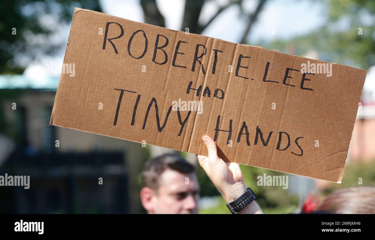 Counter protesters hold signs in front of the statue of Confederate ...