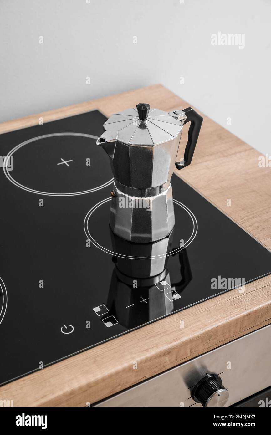 Geyser coffee maker on electric stove in kitchen near grey wall Stock ...