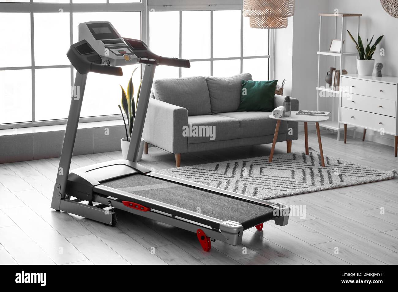 Interior of living room with modern treadmill near window Stock Photo ...