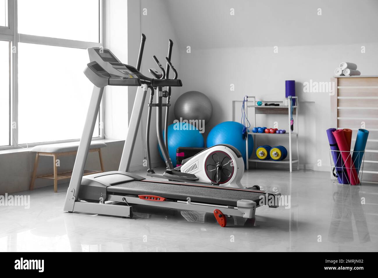 Interior of gym with modern treadmill and sport equipment near window ...