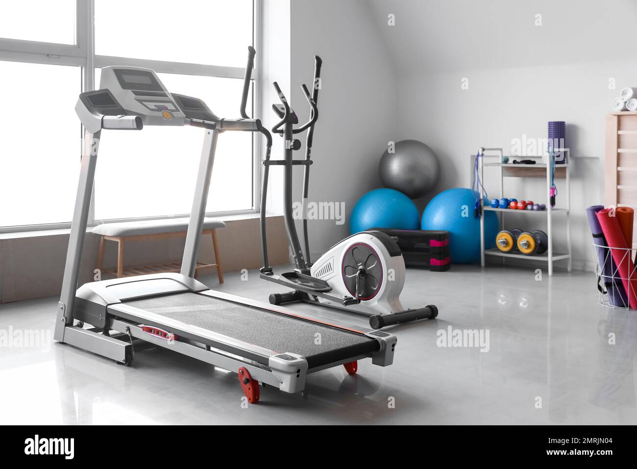 Interior of gym with modern treadmill and sport equipment near window ...
