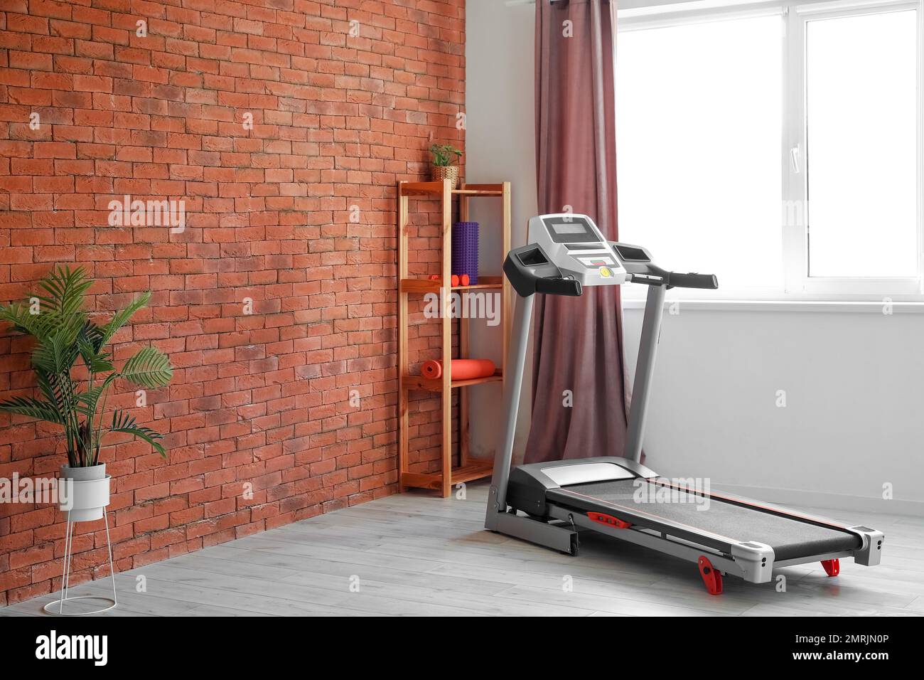 Interior of room with modern treadmill near window Stock Photo - Alamy