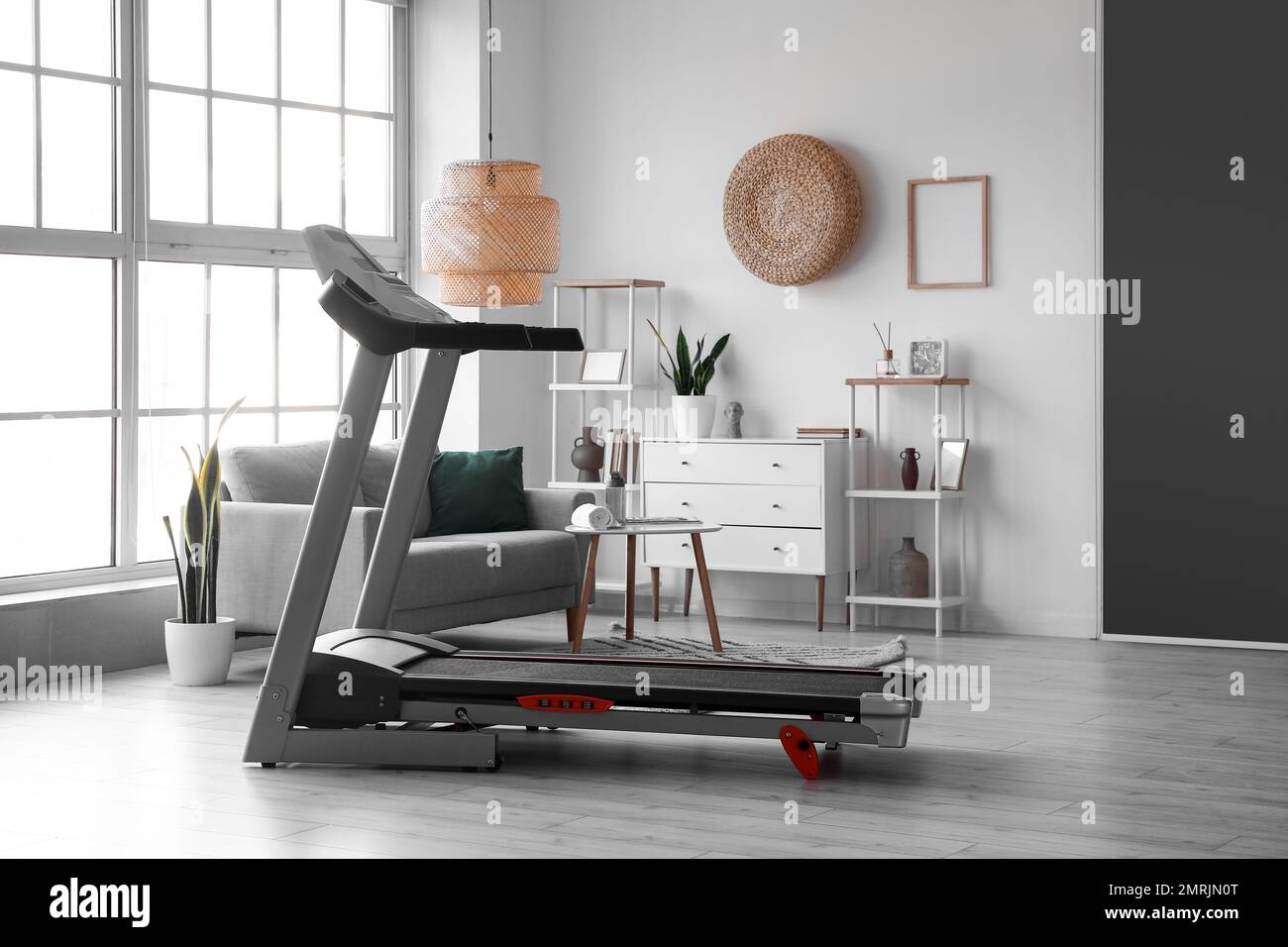 Interior of living room with modern treadmill near window Stock Photo ...