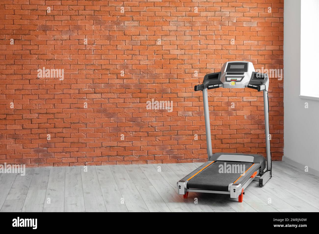 Interior of room with modern treadmill near brick wall Stock Photo - Alamy