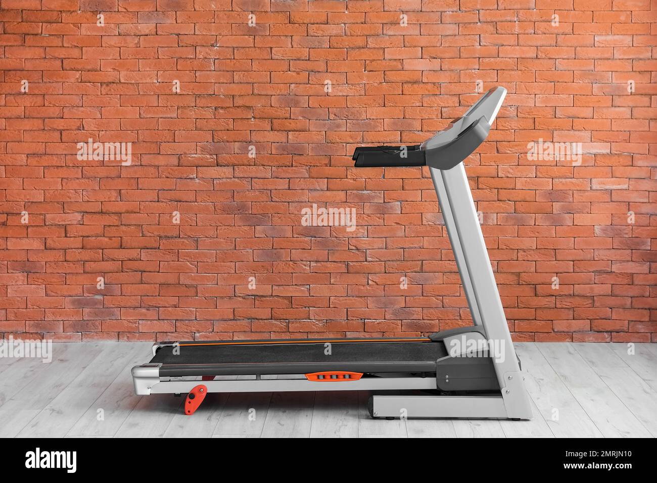 Interior of room with modern treadmill near brick wall Stock Photo - Alamy