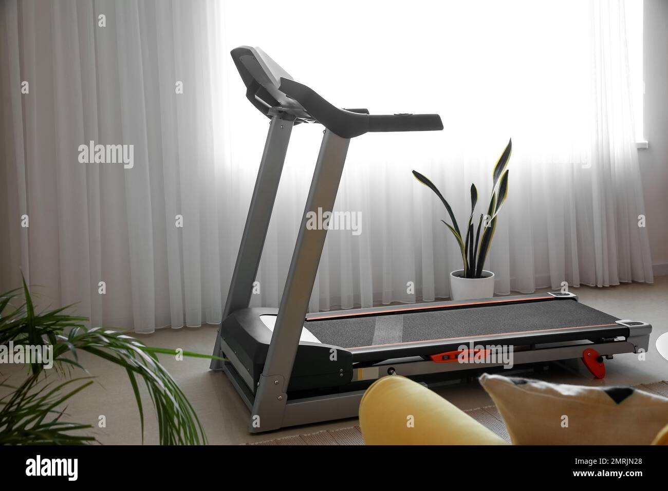 Interior of living room with modern treadmill near window Stock Photo ...