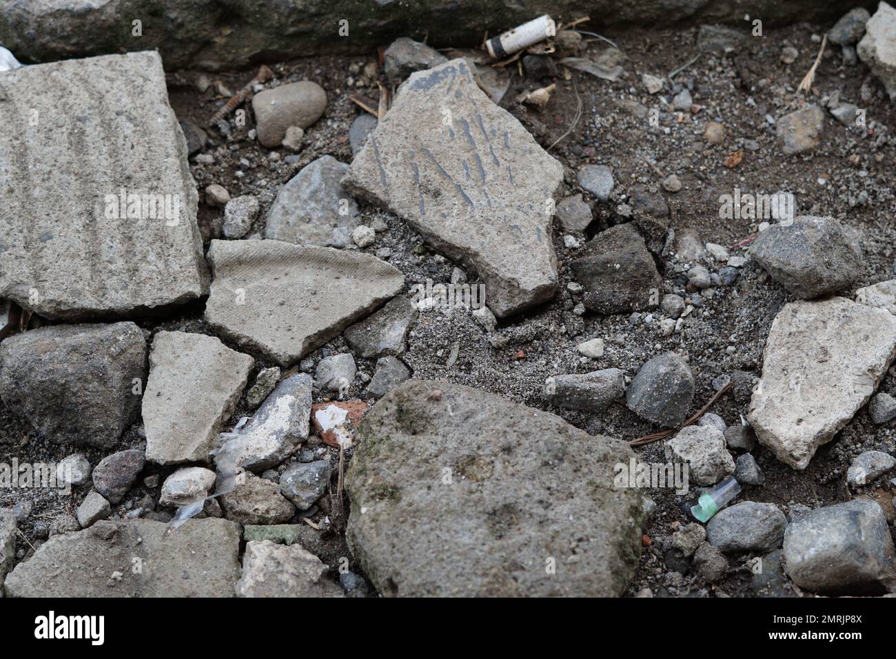 A pile of white bricks stacked and lying on the ground at a ...