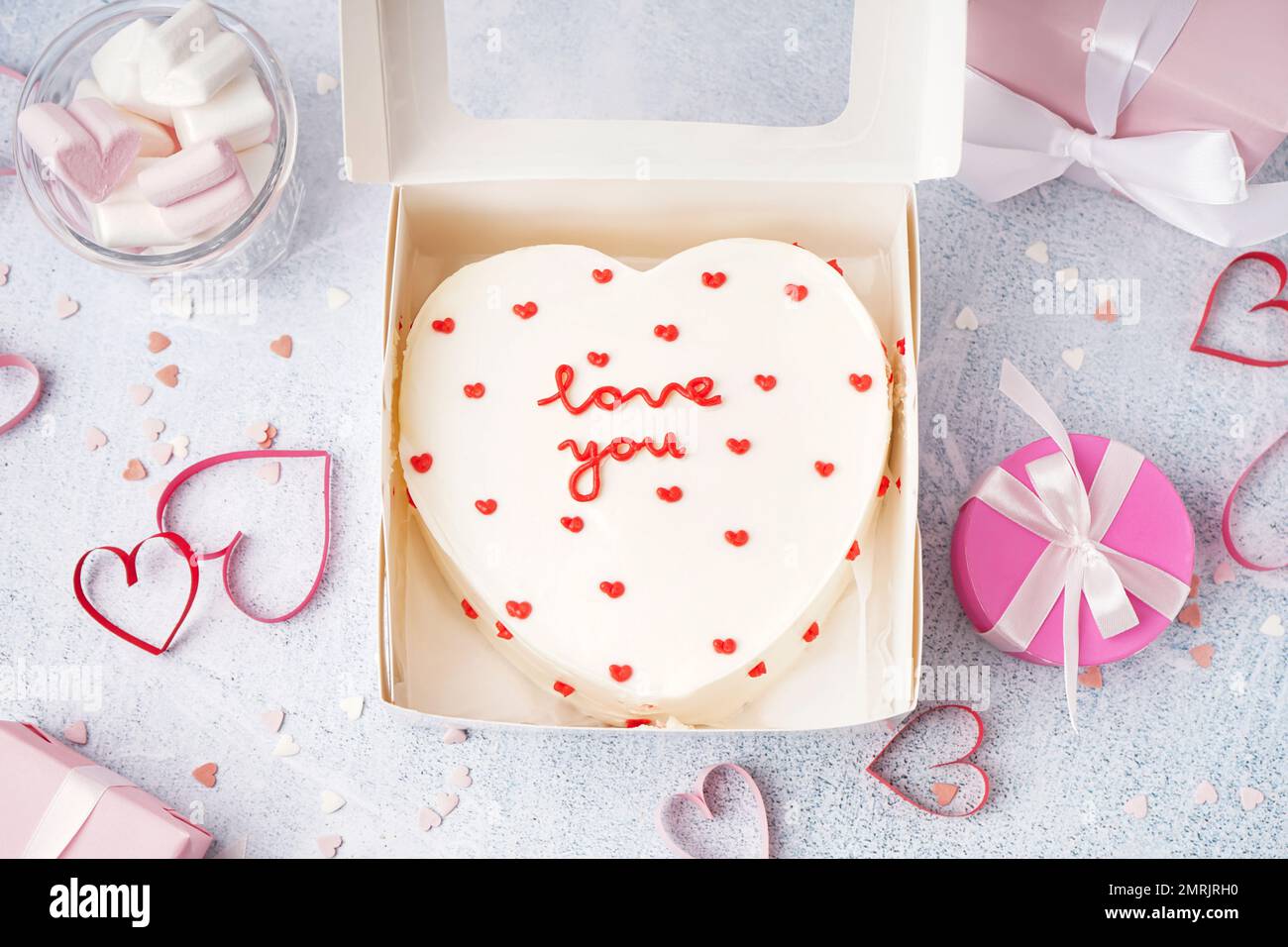 Box with heart-shaped bento cake and gifts on grey background ...