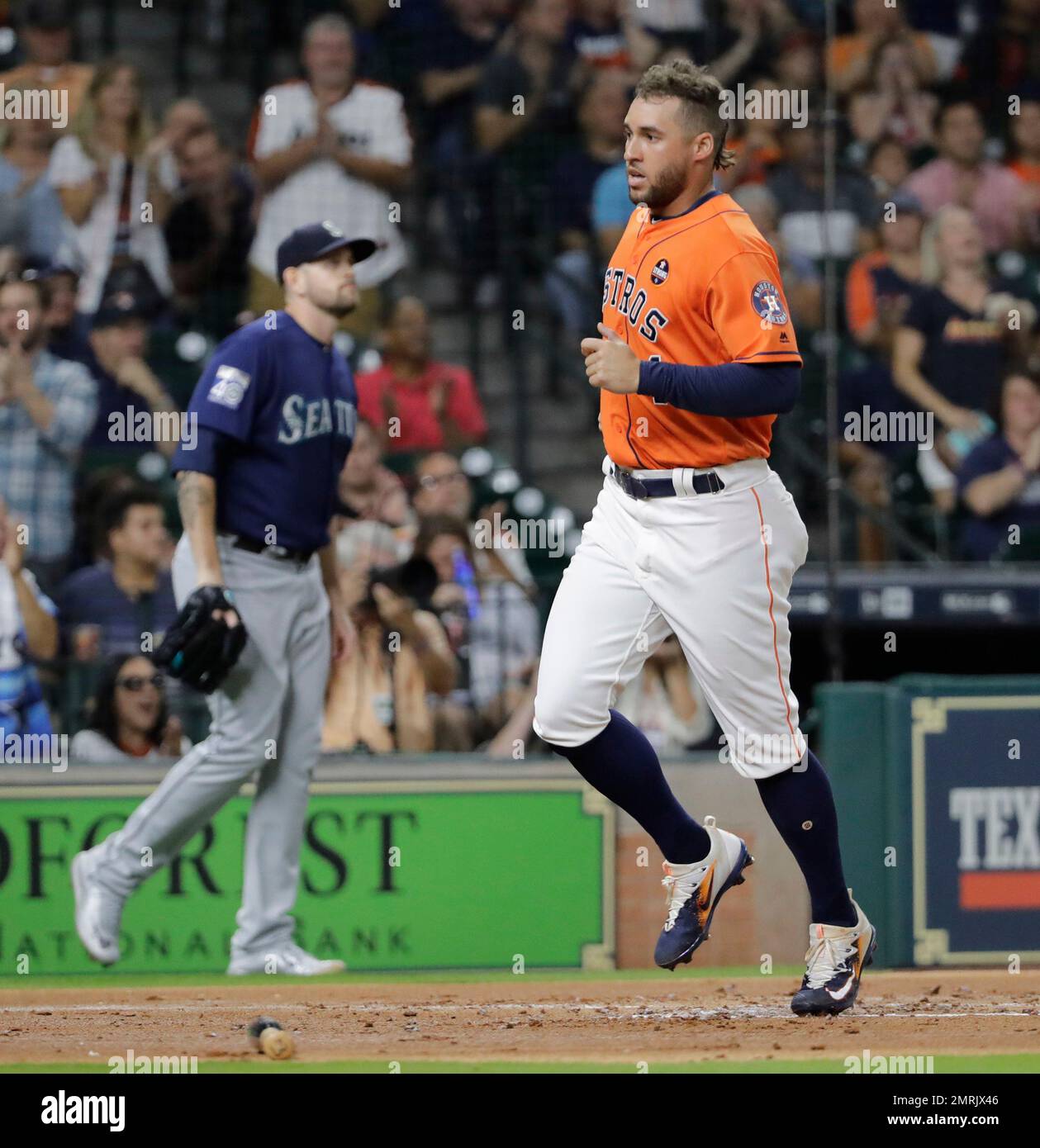 Houston Astros' George Springer, right, scores on a single by Jose Altuve during the first ...