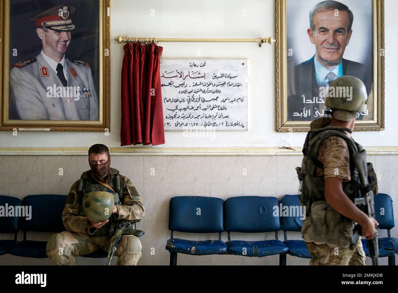 A Russian military policeman, left, rests in the lobby of a hospital in ...