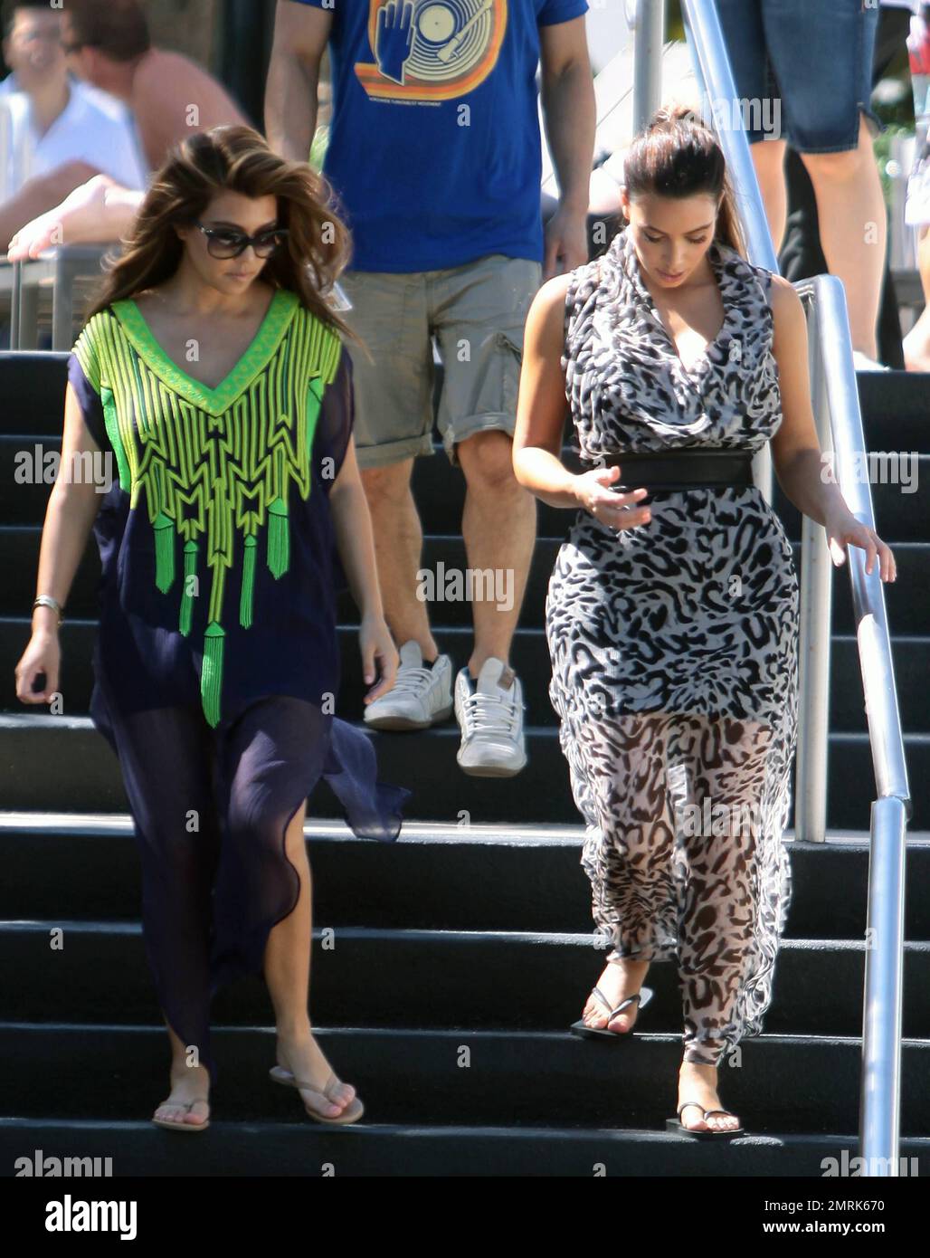 Kim Kardashian and sister Kourtney take a stroll on the beach while ...