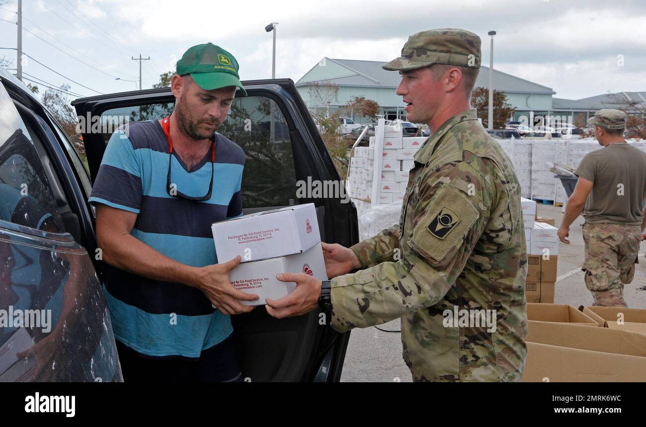 A member of the National Guard hands over boxes of food to Patrick ...