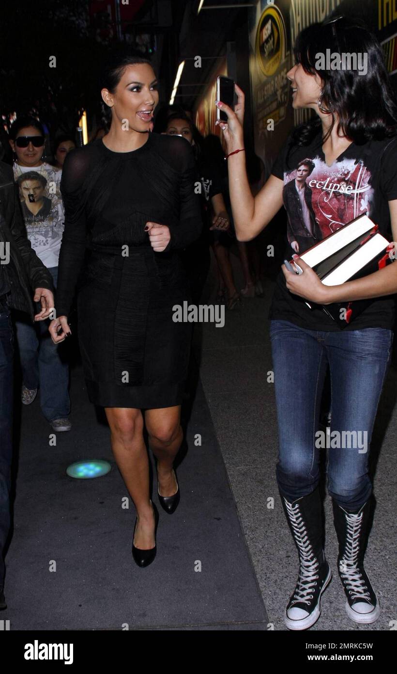 Kim Kardashian flashes a peace sign and signs autographs for fans as ...