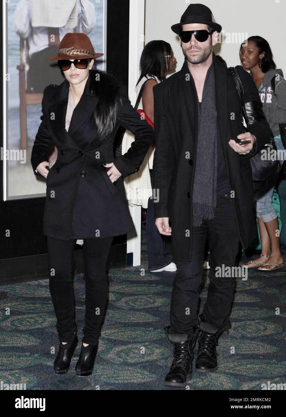 Looking cool and collected in a trendy brown fedora, black pea coat ...