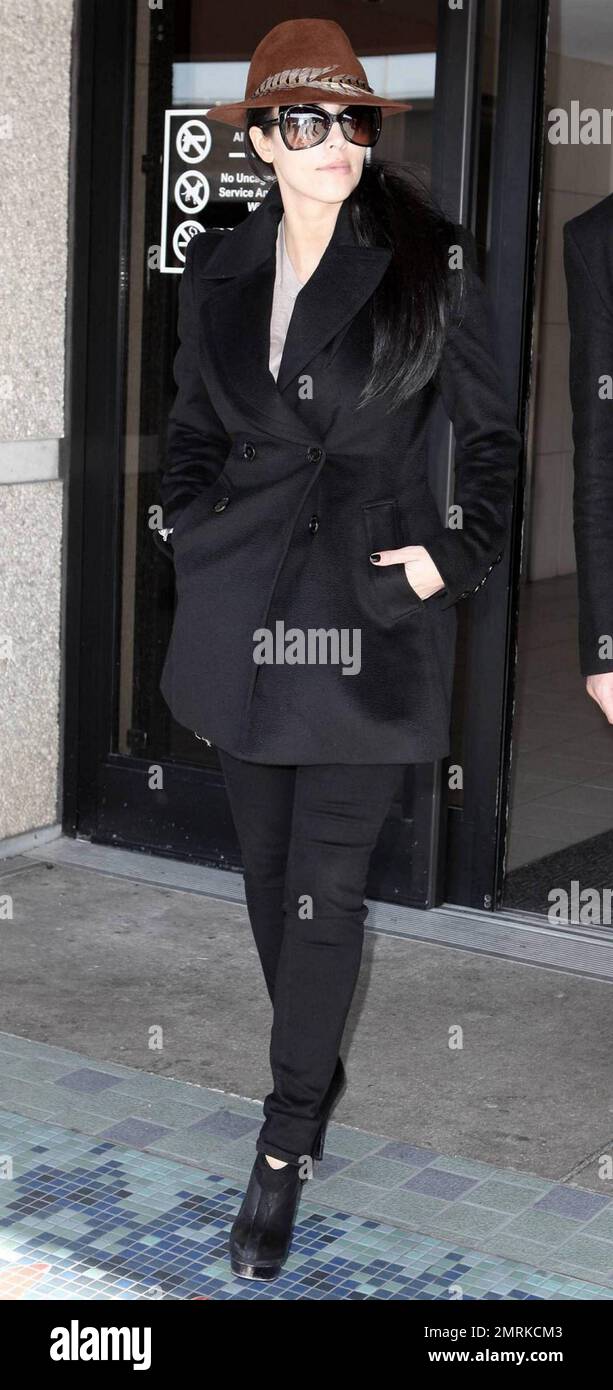 Looking cool and collected in a trendy brown fedora, black pea coat ...