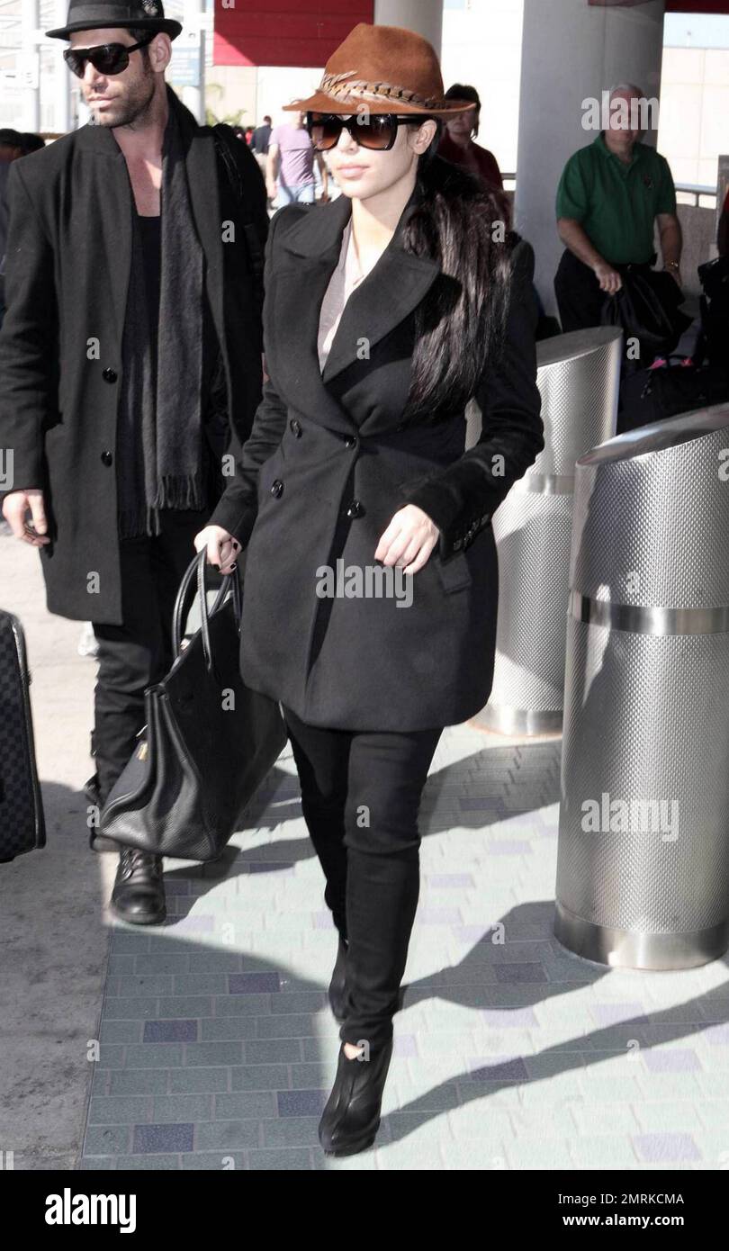 Looking cool and collected in a trendy brown fedora, black pea coat ...