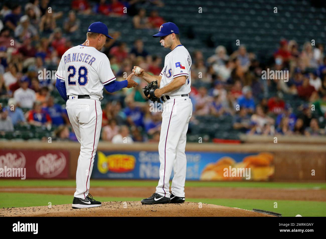 Texas Rangers manager Jeff Banister (28) takes the ball from starting ...