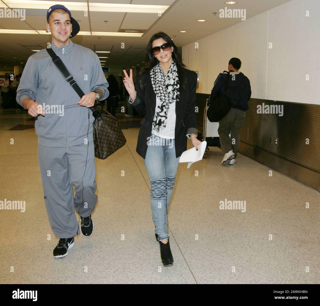 Kim Kardashian flashes a peace sign as she arrives at Miami Airport ...