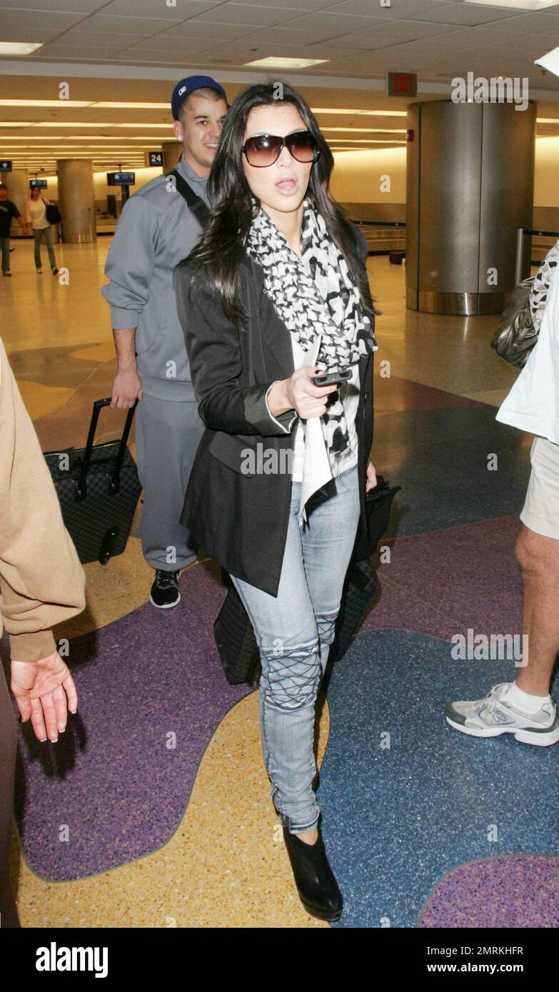 Kim Kardashian flashes a peace sign as she arrives at Miami Airport ...
