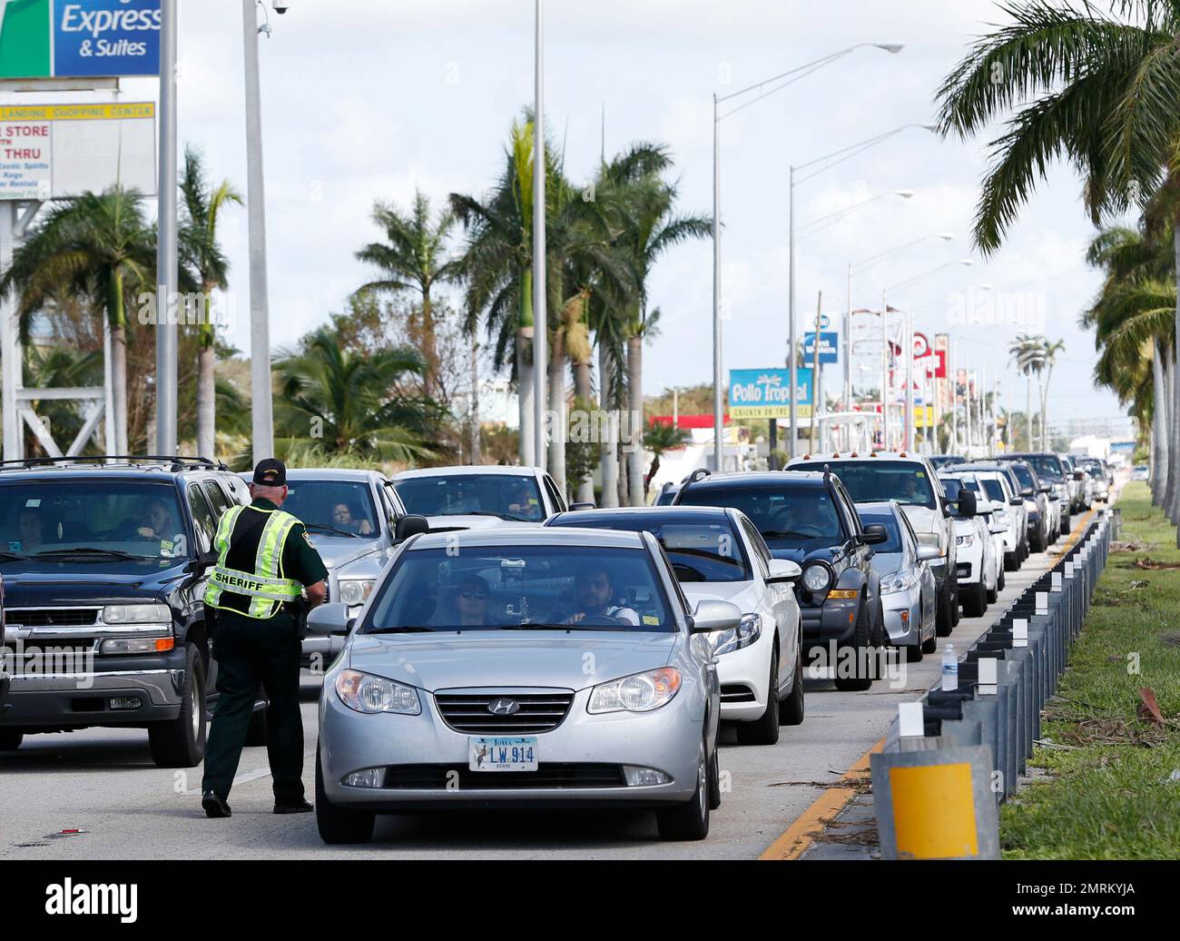 A police officer directs motorists at a checkpoint as Florida Keys ...